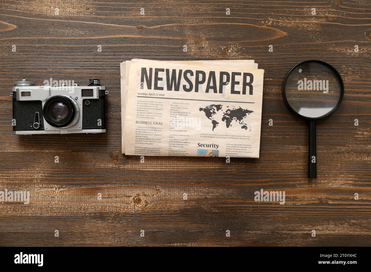 Morning newspaper, magnifying glass and photo camera on wooden ...