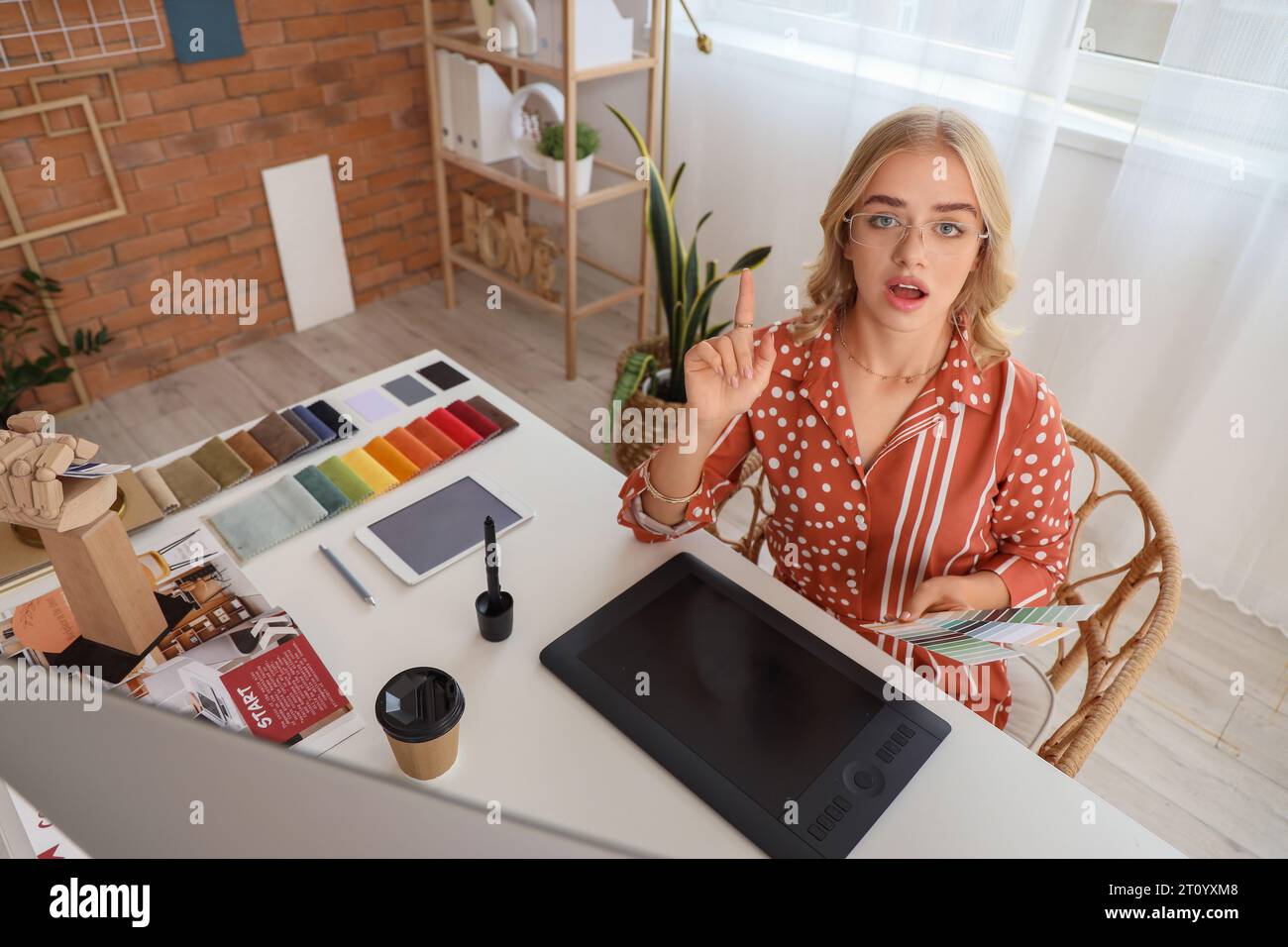 Female interior designer with color palettes having idea at table in ...