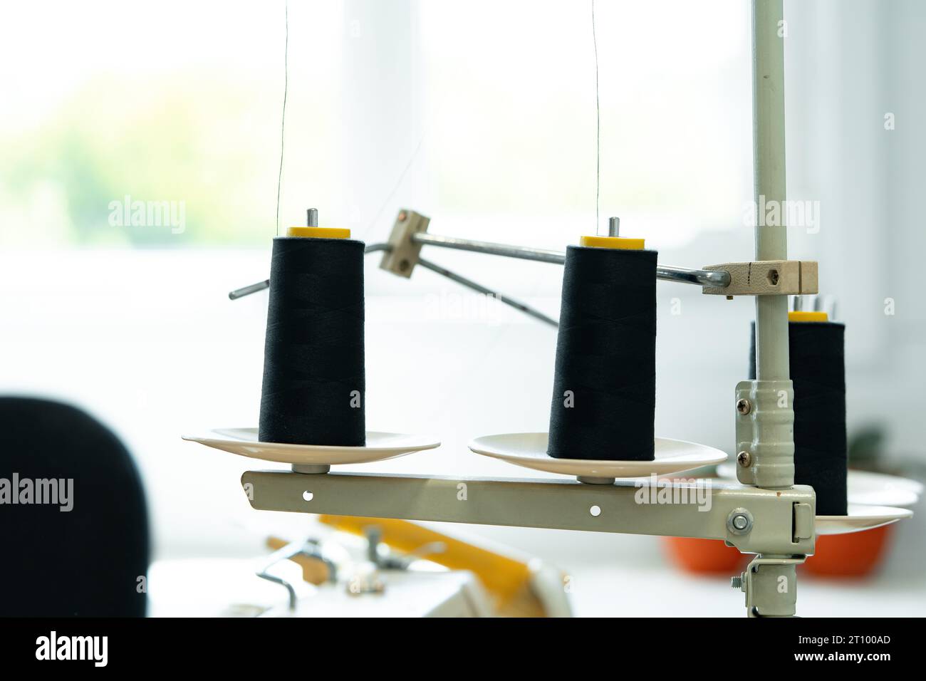 Thread bobbin on overlock sewing machine close up Stock Photo - Alamy
