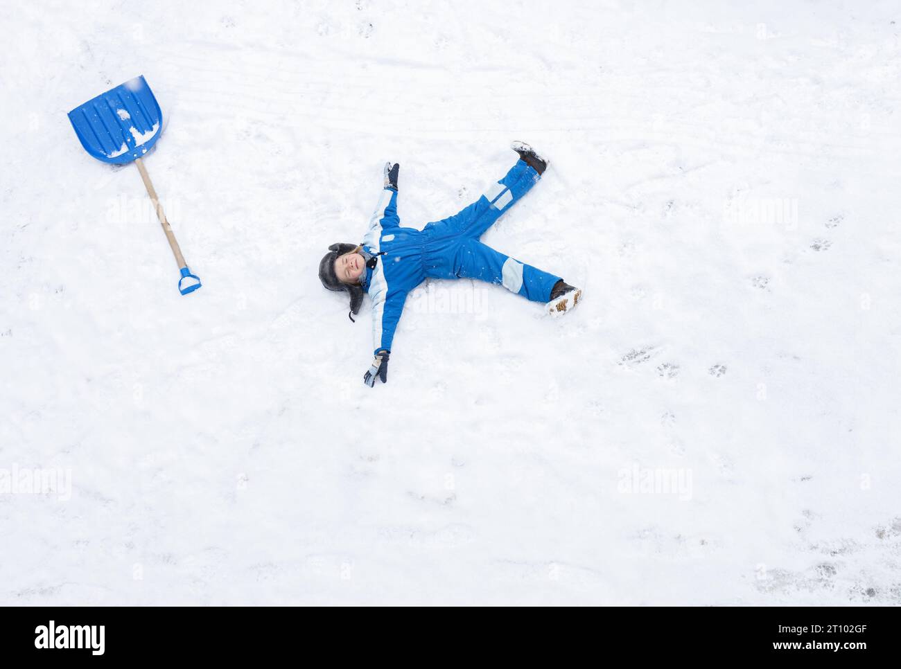 boy in blue winter suit cleared snow after blizzard and lay down on ...