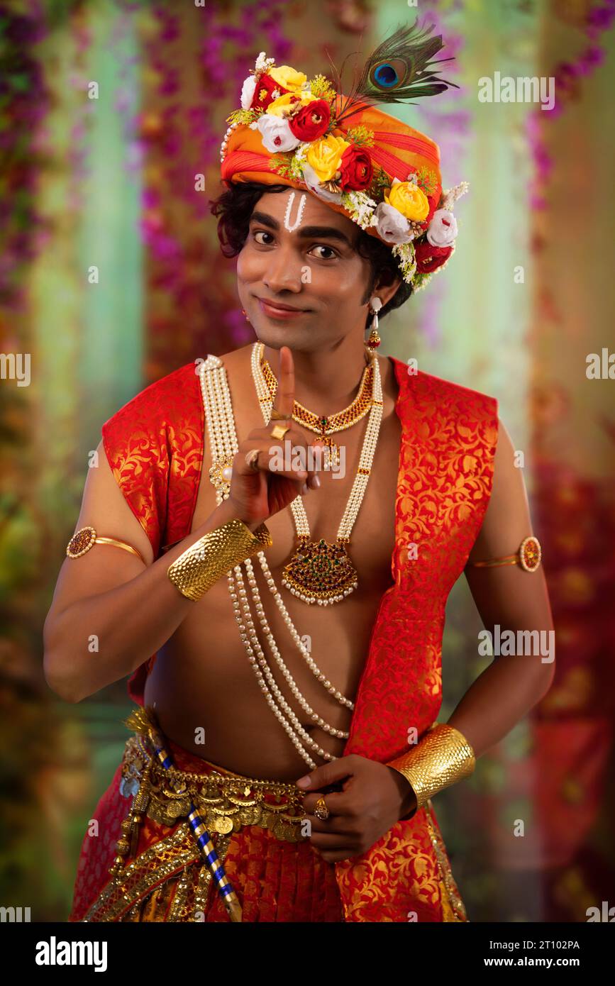 Young man dressed up as Lord Krishna and gesturing on the occasion of ...