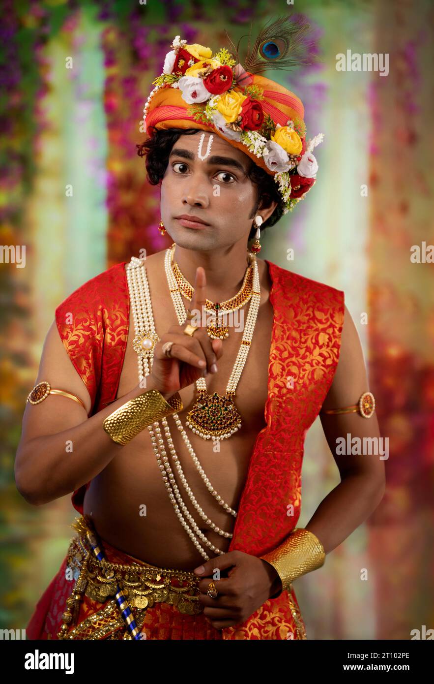 Young man dressed up as Lord Krishna and gesturing on the occasion of ...