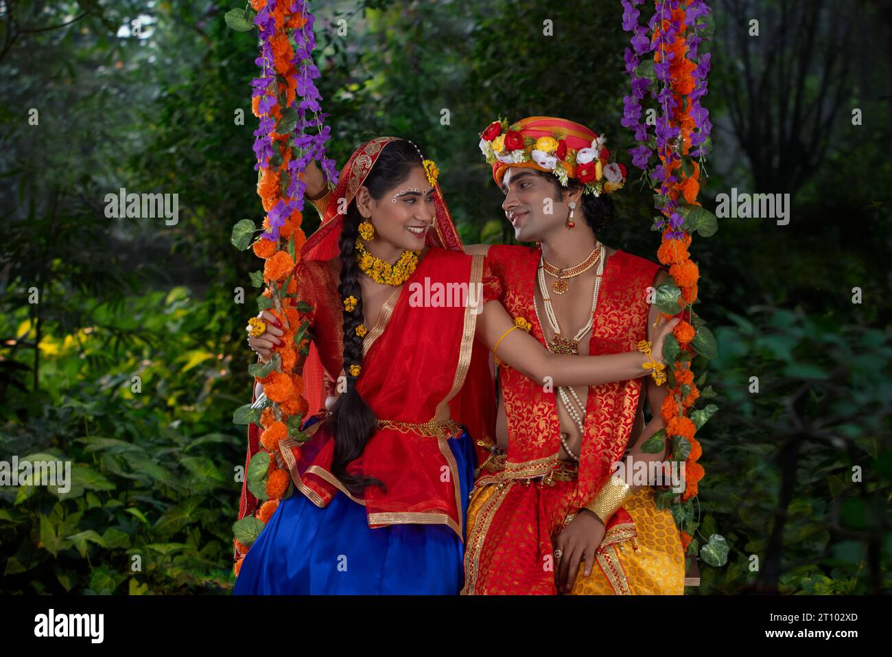 Young man and woman dressed up as Radha and Krishna and sitting ...