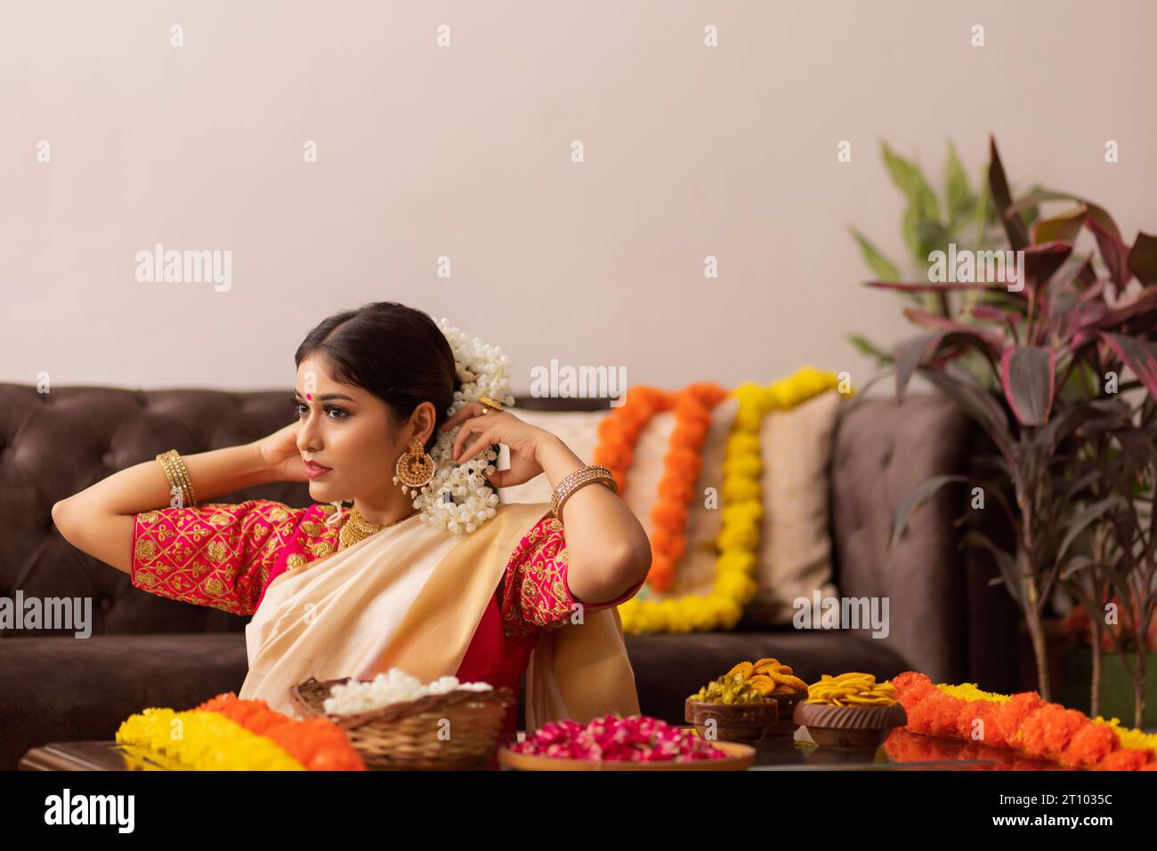 Woman decorating her hair bun with flower garland on Onam Stock Photo ...
