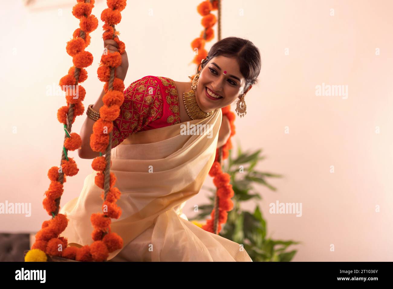 Woman in traditional clothing sitting on a swing decorated with flowers ...