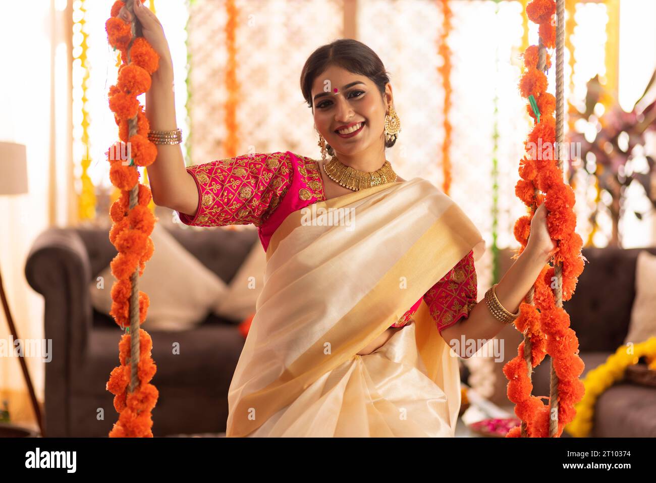 Woman in traditional clothing sitting on a swing decorated with flowers ...
