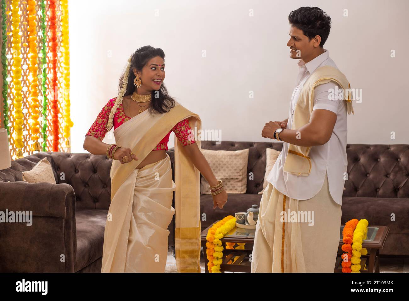South Indian couple in traditional outfit dancing at home on the ...