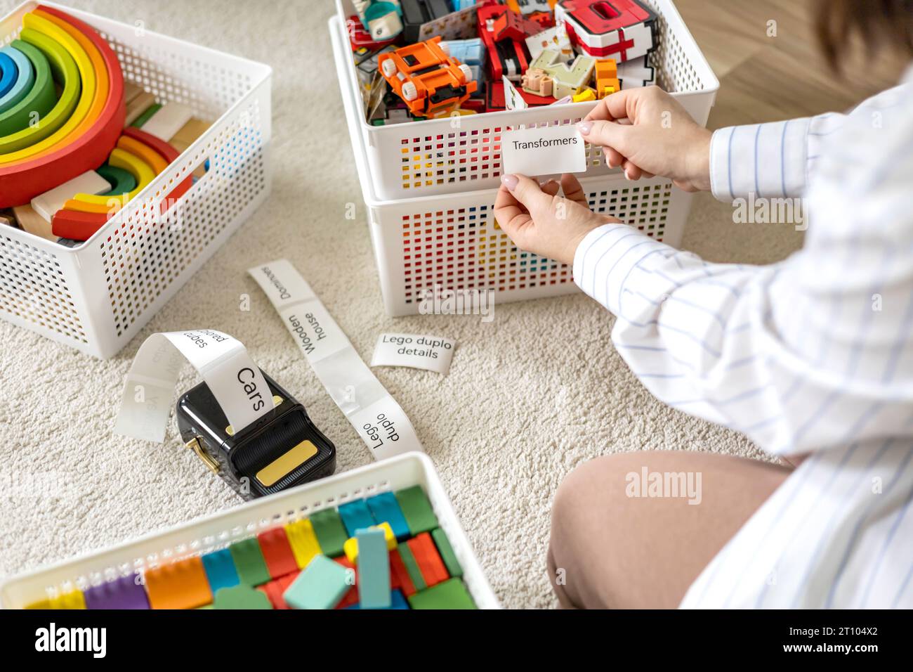 Woman clean out childish room sorting wooden and plastic toys use ...