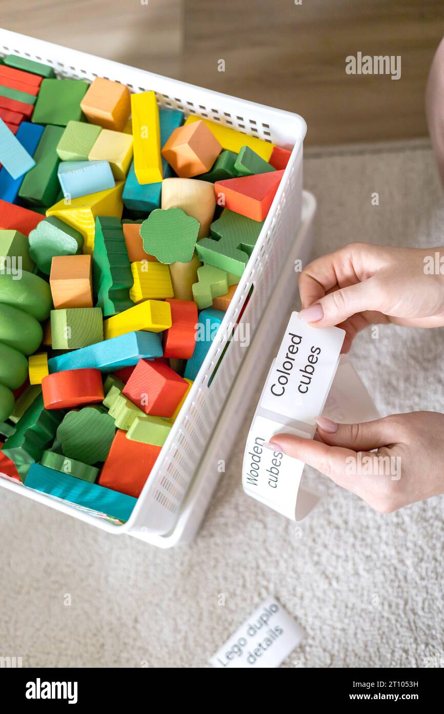 Woman clean out childish room sorting wooden and plastic toys use ...