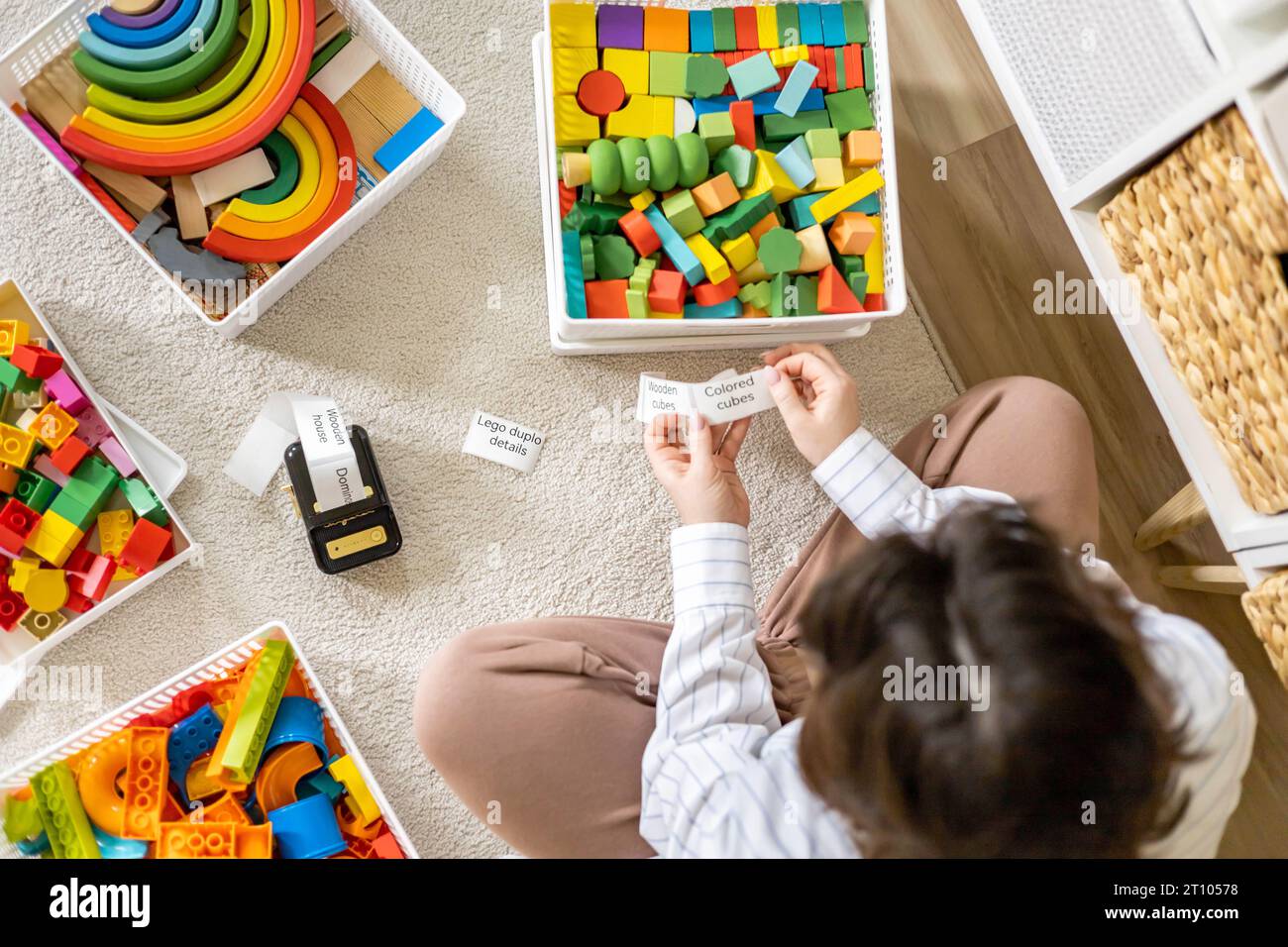 Woman clean out childish room sorting wooden and plastic toys use ...