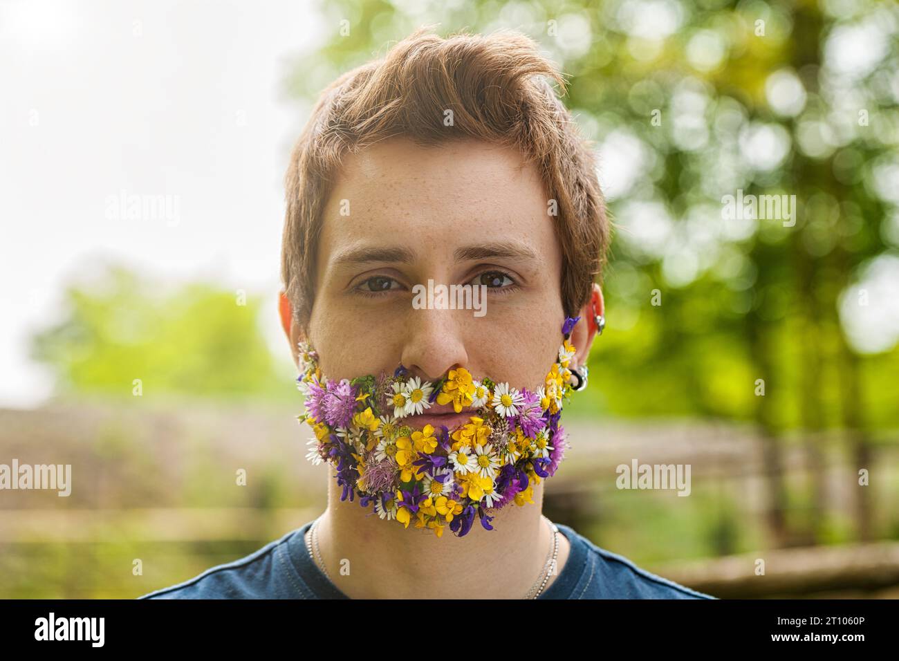 Nature provides backdrop to a redhead, face adorned with blooms ...