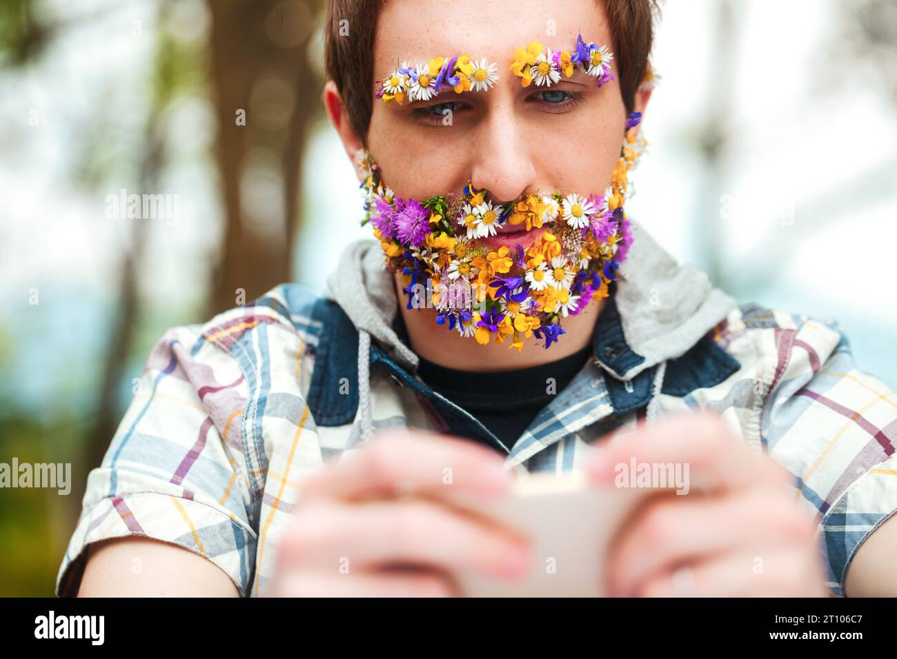 With a beard and eyebrows made of vibrant spring blooms, a man sits in ...