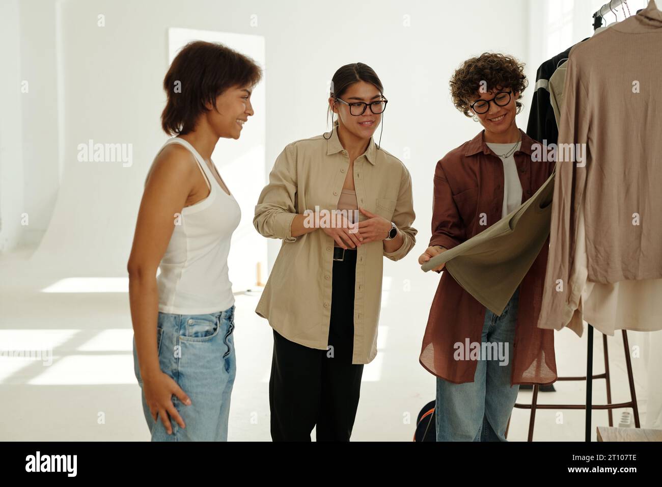 Group of happy young stylist, fashion model and photographer consulting ...