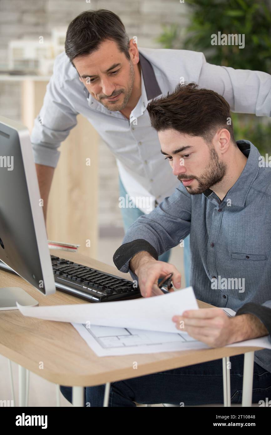 supervisor looking over junior architects work Stock Photo - Alamy