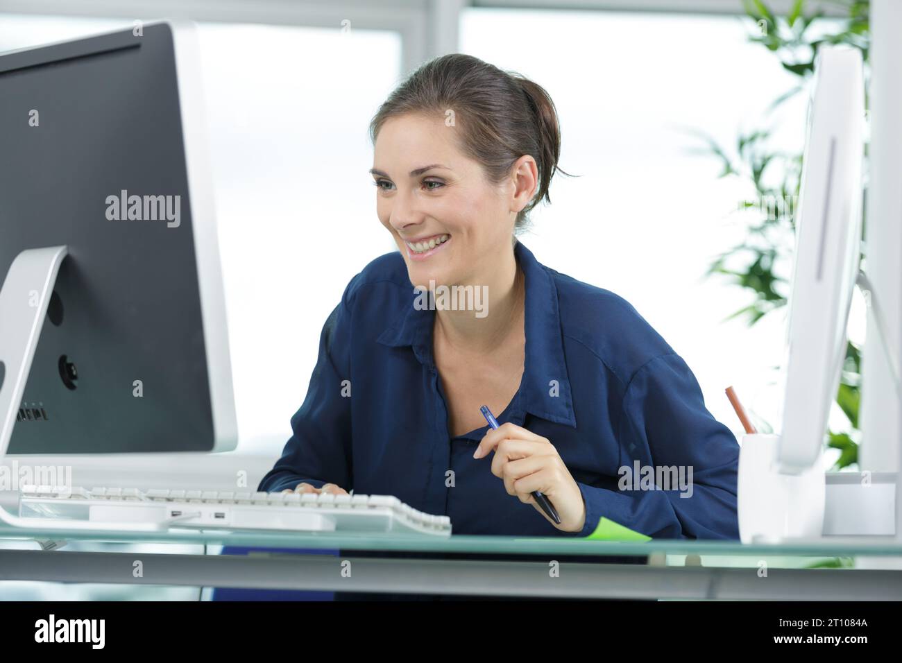 woman laughing while using desktop computer Stock Photo - Alamy