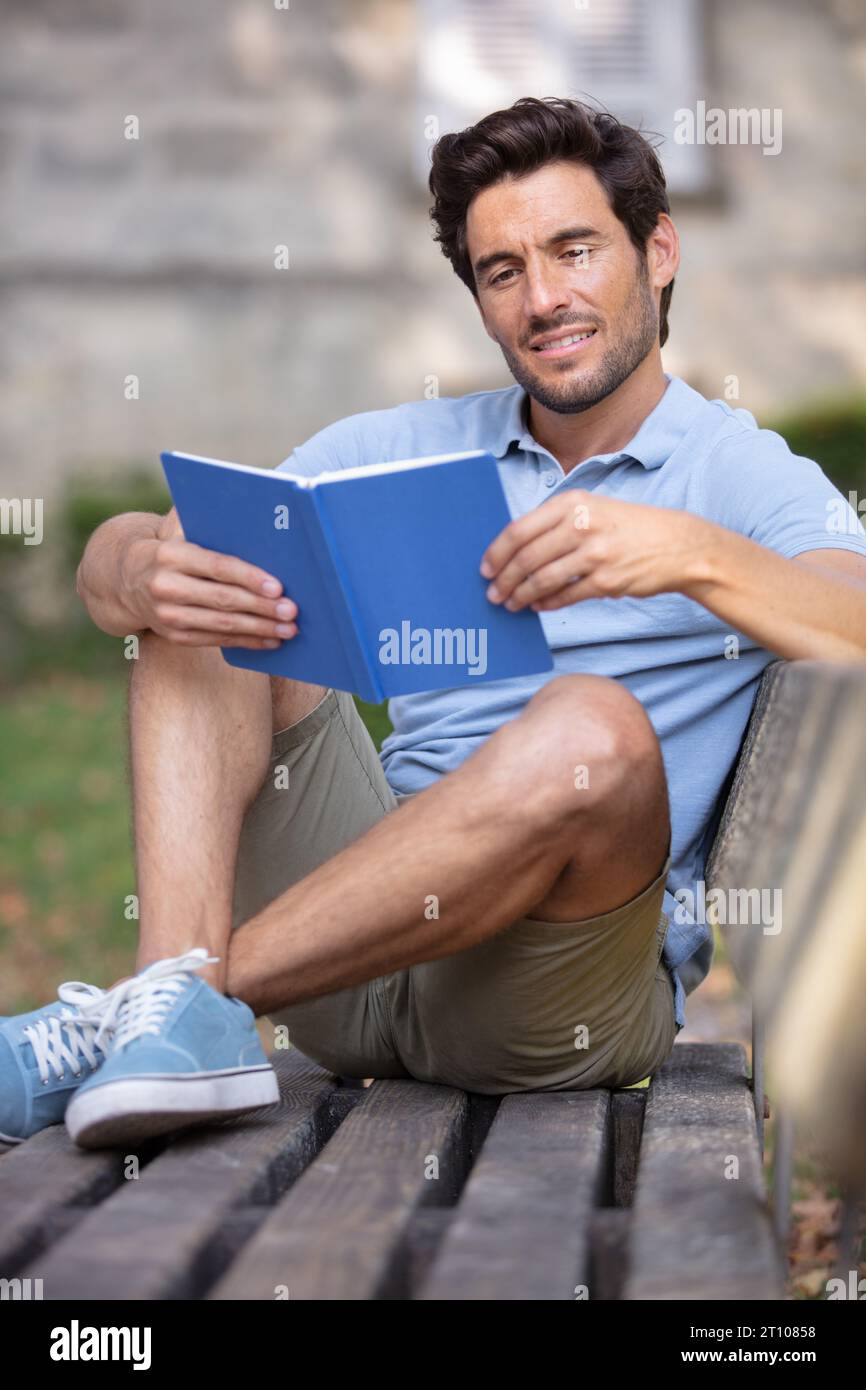 man holds a notebook sitting on a bench Stock Photo - Alamy