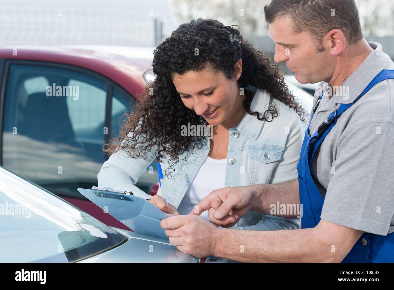 female customer signing mechanics paperwork Stock Photo - Alamy