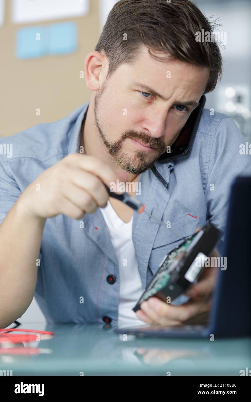 young technician working on broken computer Stock Photo - Alamy