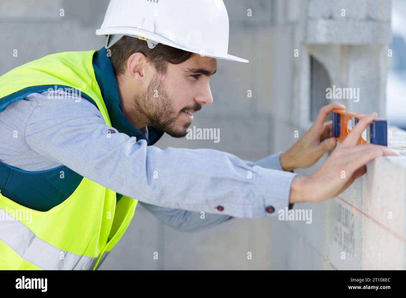 man bricklayer is measurement level Stock Photo - Alamy