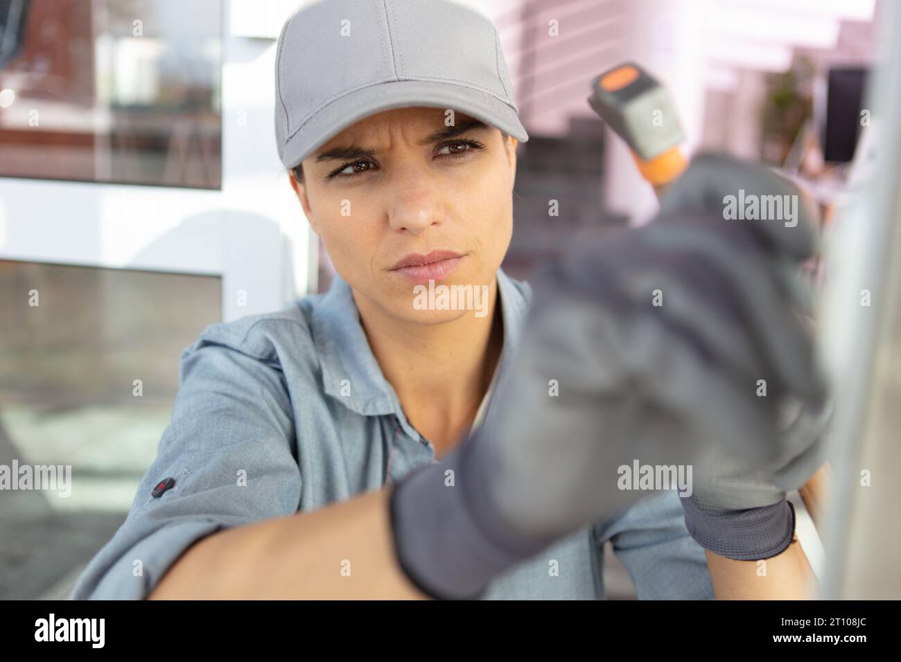low angle of young woman working installing windows Stock Photo - Alamy