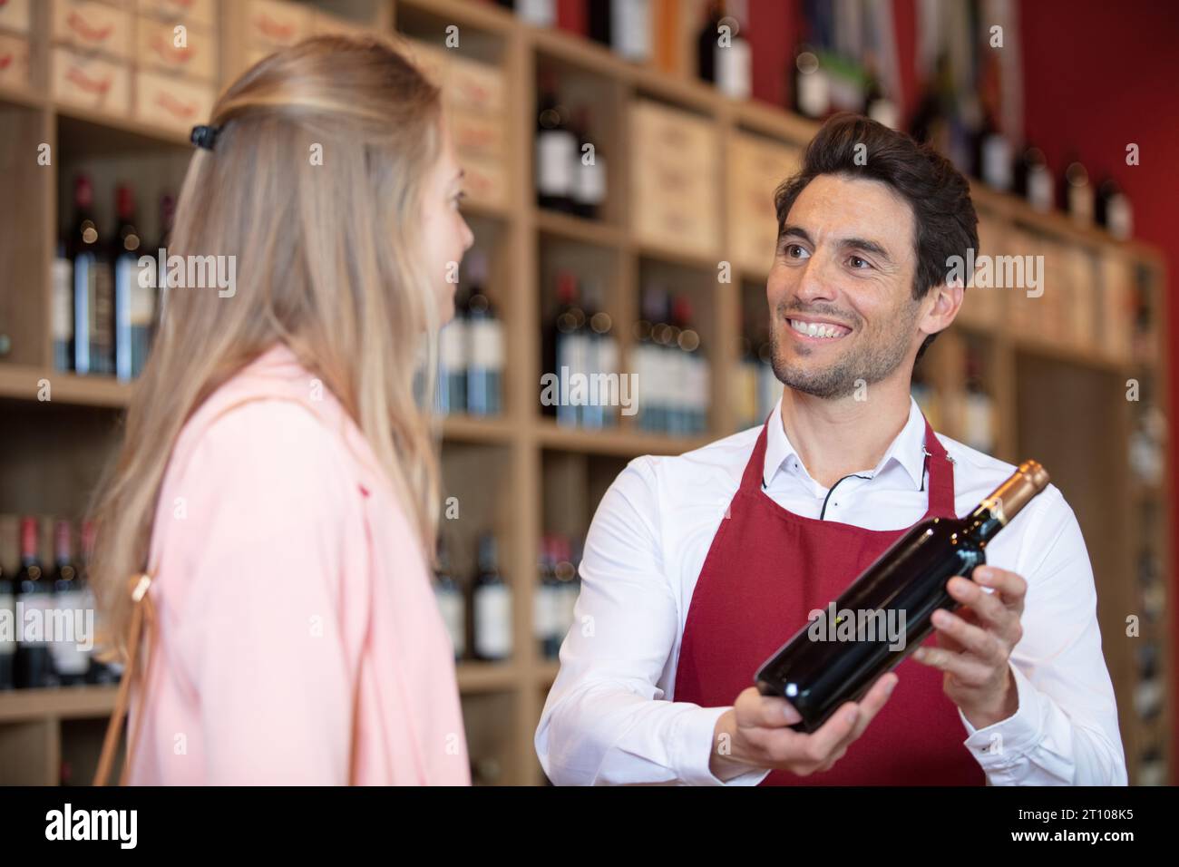 male vendor serving red wine to female customer Stock Photo - Alamy