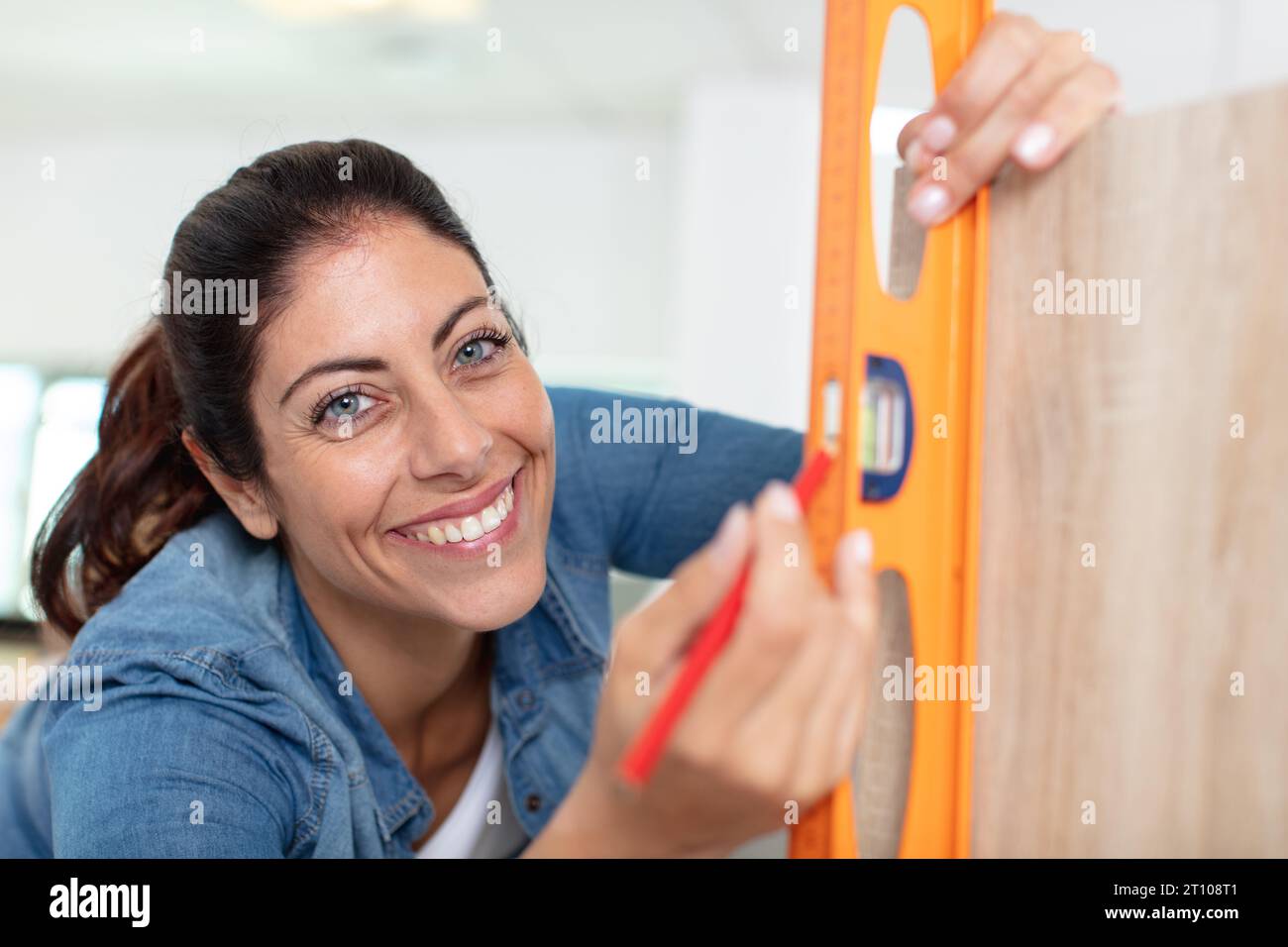 female construction worker checking level of the wall Stock Photo - Alamy