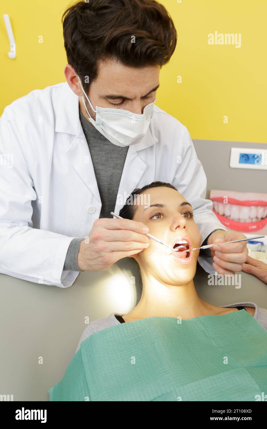 Dentist performs teeth cleaning procedure hi-res stock photography and ...