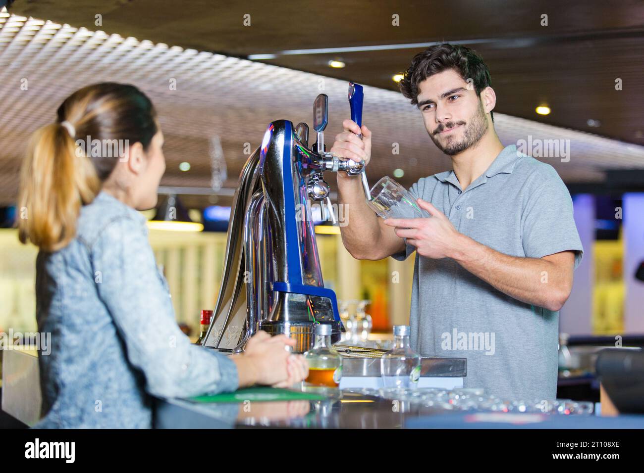 waiter making a drink for a female customer Stock Photo - Alamy
