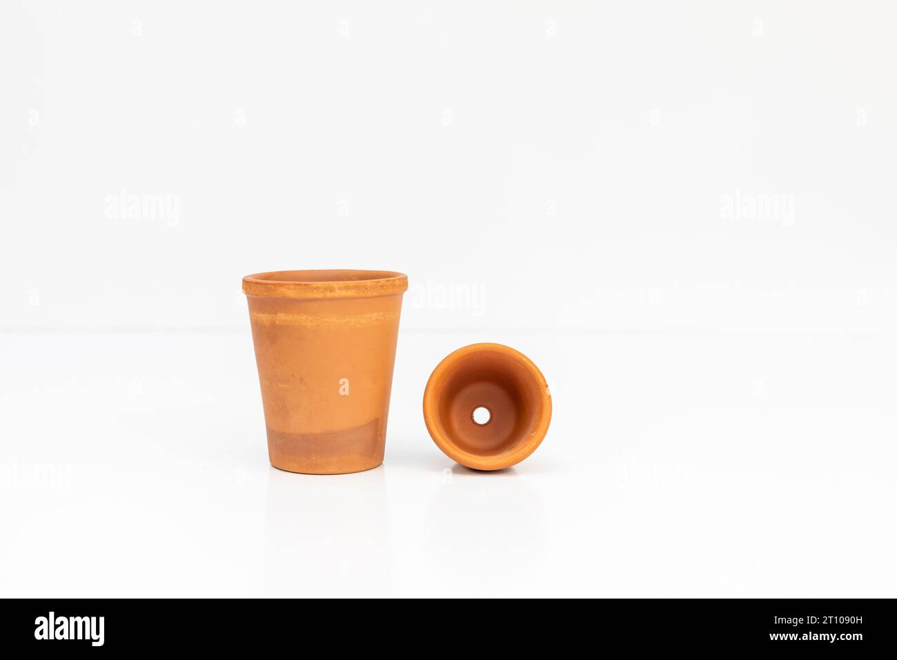 Different sizes of miniature terracotta pots on white isolated ...