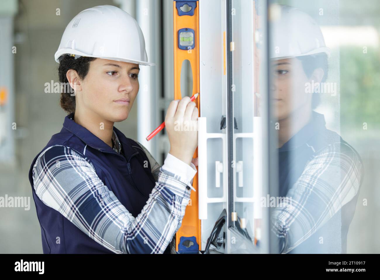 woman builder holding builders level Stock Photo - Alamy