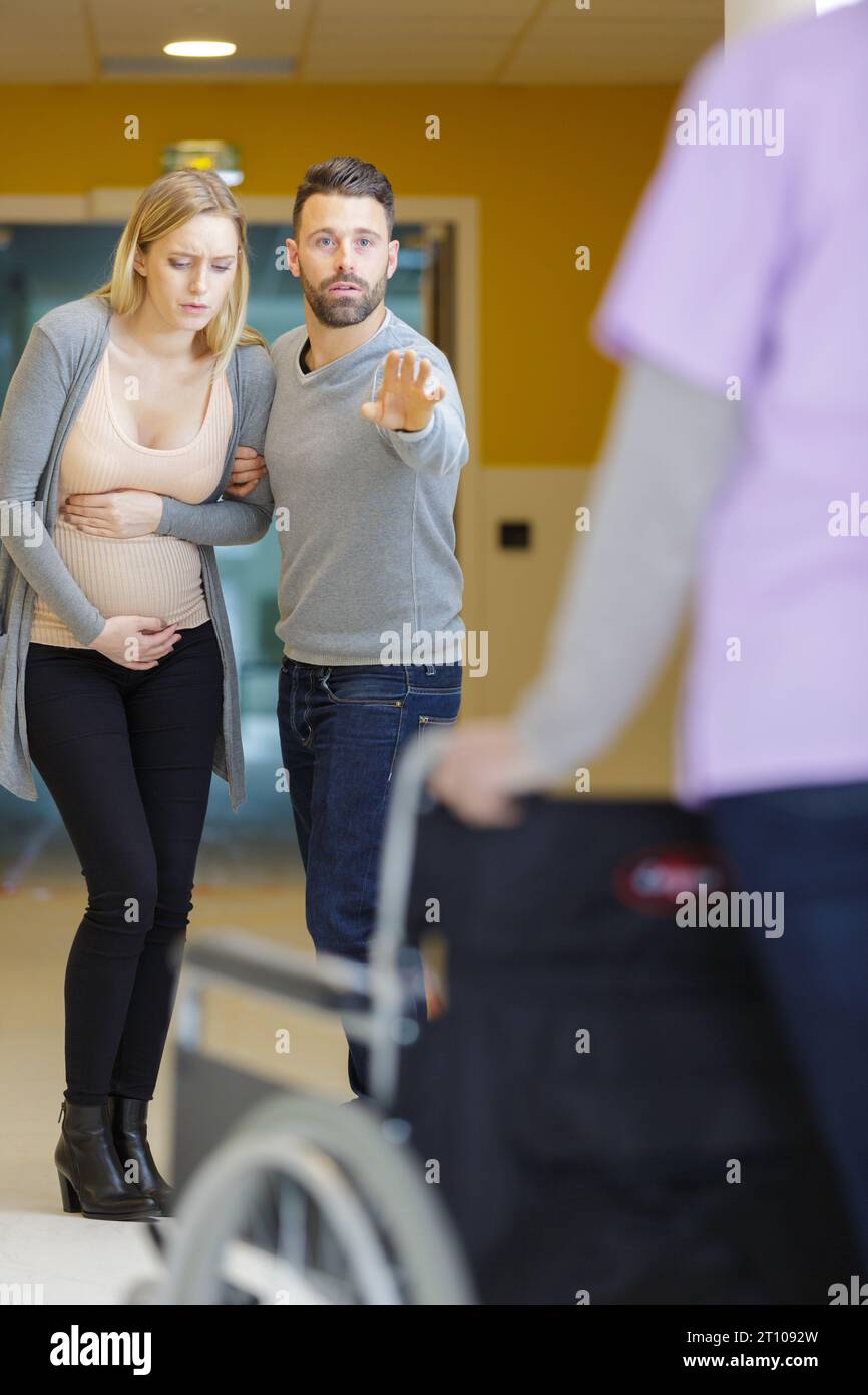 pregnant in pain and man asking for assistance Stock Photo - Alamy