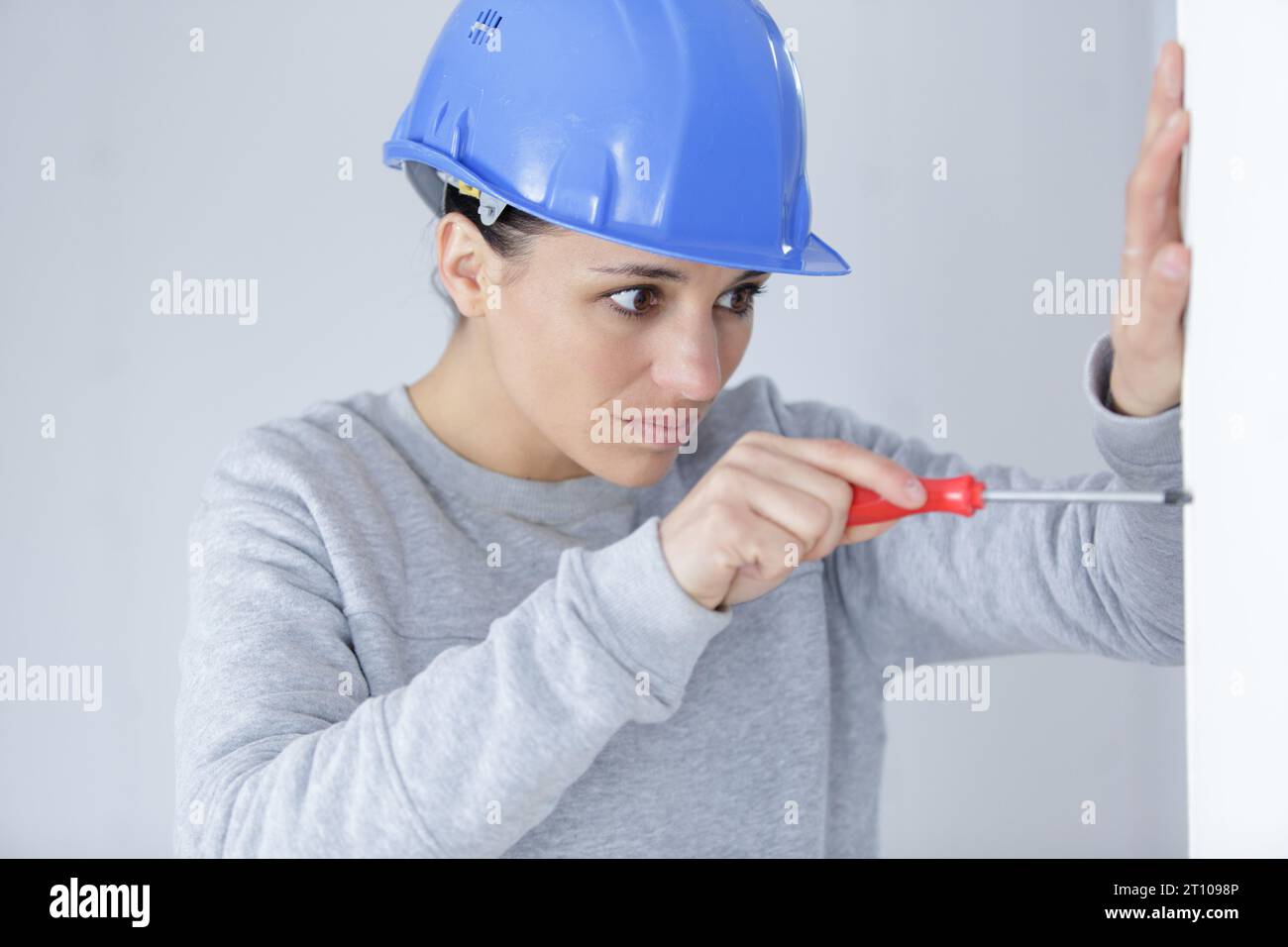 happy female builder with screwdriver fixing socket indoors Stock Photo ...