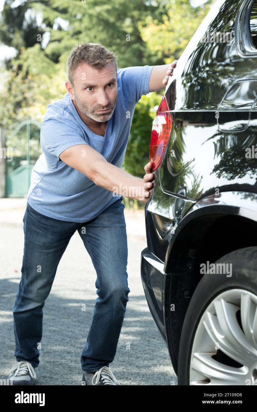 a man pushing damaged car Stock Photo - Alamy