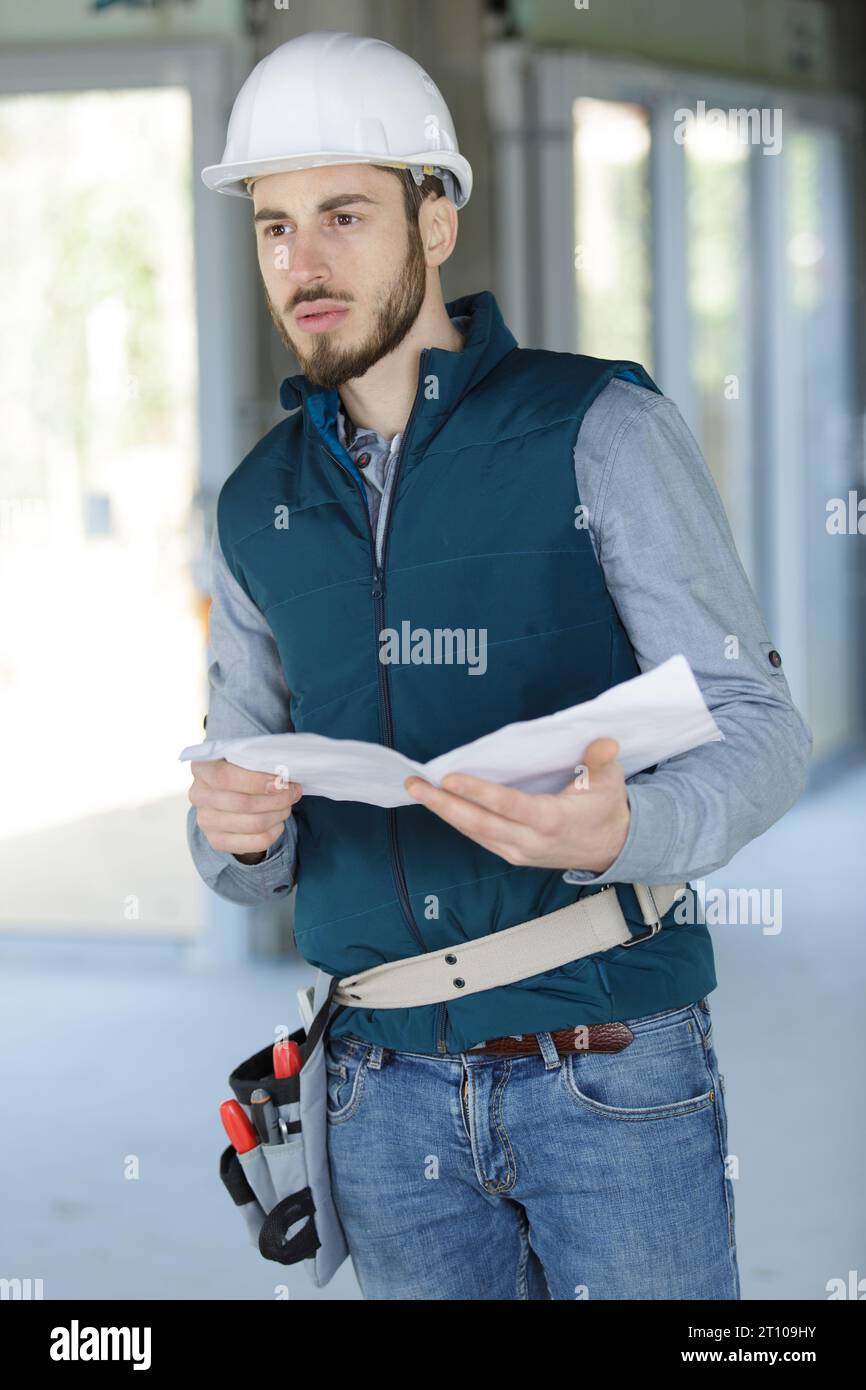 builder man checks plans project Stock Photo - Alamy