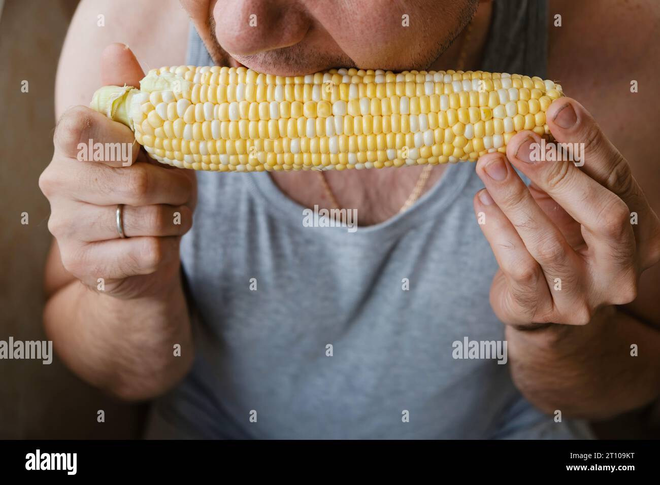 A man bites a cob of corn, close-up of an unrecognizable man Stock ...