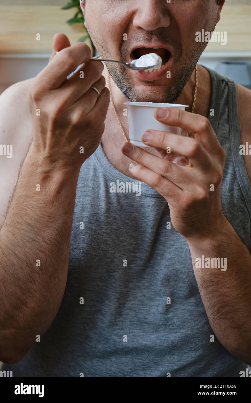 Healthy breakfast variety. Yogurt with fruit and seeds. Man eating ...