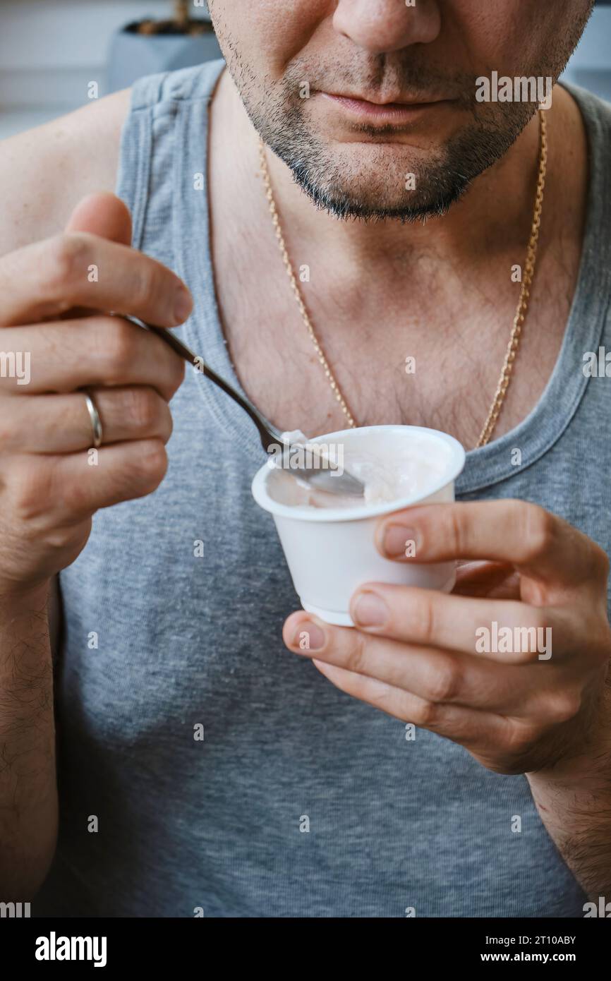 Healthy breakfast variety. Yogurt with fruit and seeds. Man eating ...