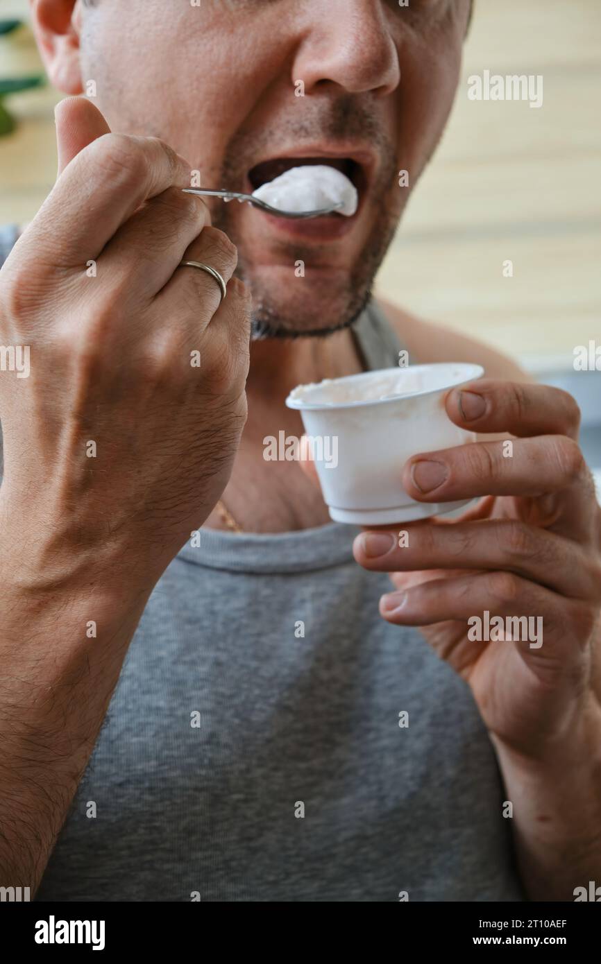 Healthy breakfast variety. Yogurt with fruit and seeds. Man eating ...
