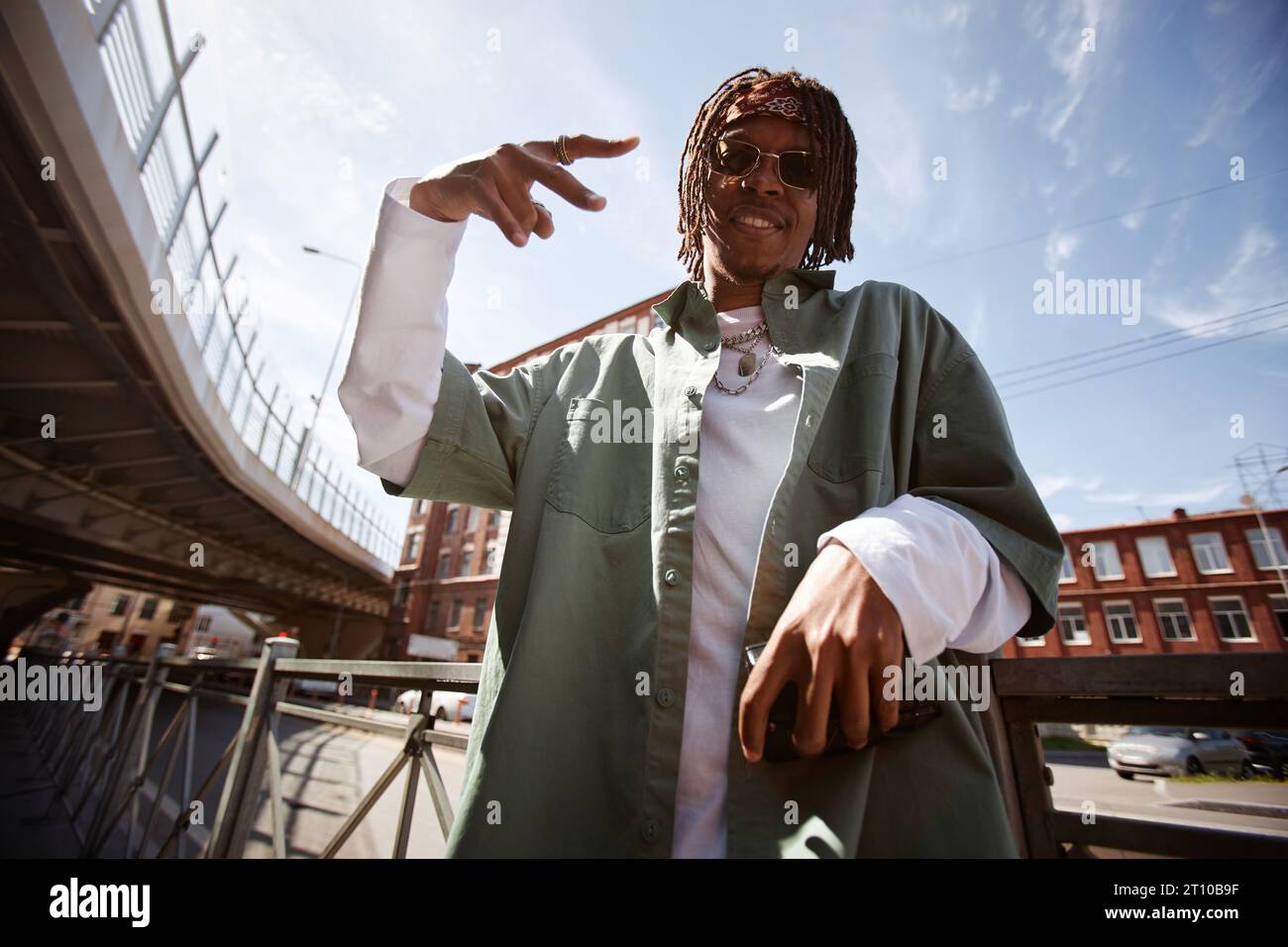 Happy young African American man with dreadlocks performing hip hop ...