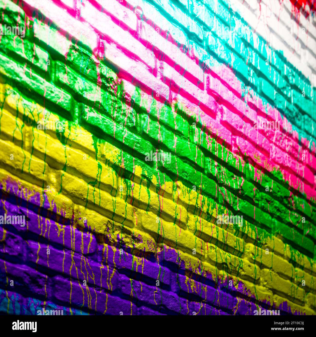 A Brick wall completely painted with vibrant neon horizontal stripes ...