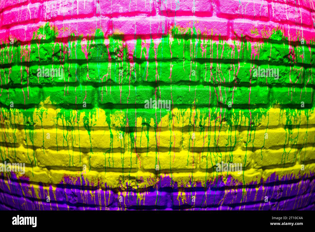 A Brick wall completely painted with vibrant neon horizontal stripes ...