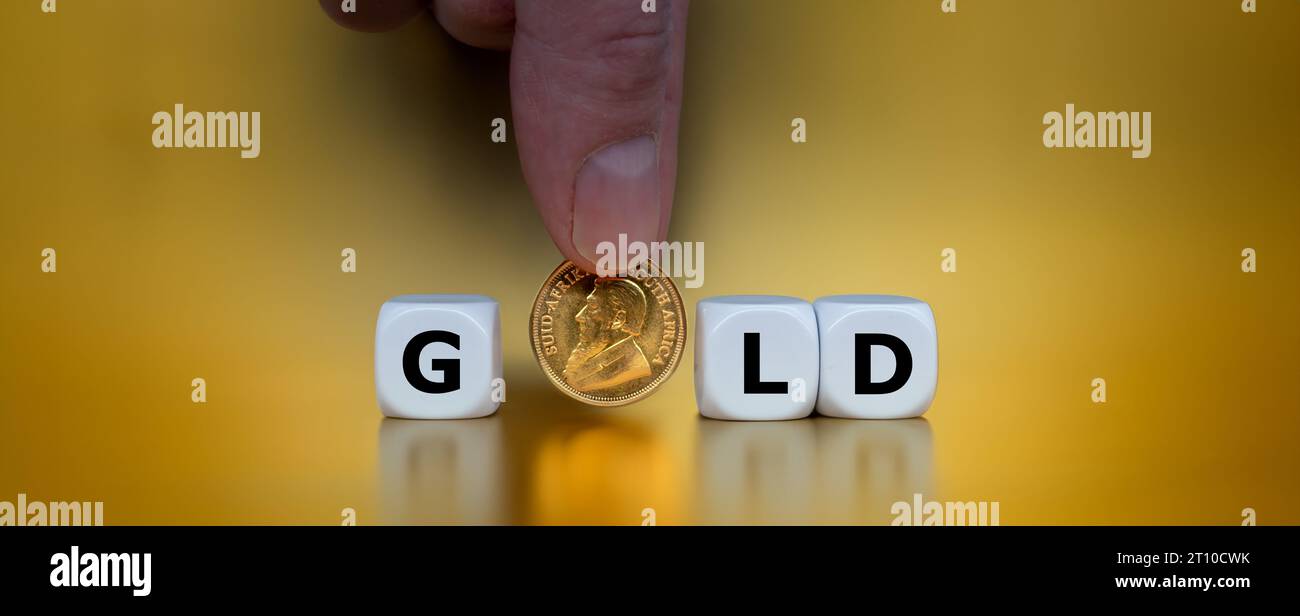 Dice form the word gold in front of a golden background Stock Photo - Alamy