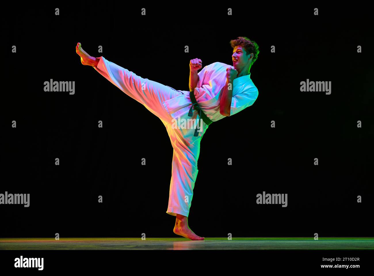 Leg kick. Professional combat sport athlete, karateka in white kimono ...