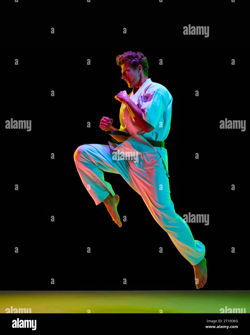 Knee kick. Young man in white kimono practicing karate punches, kicks ...