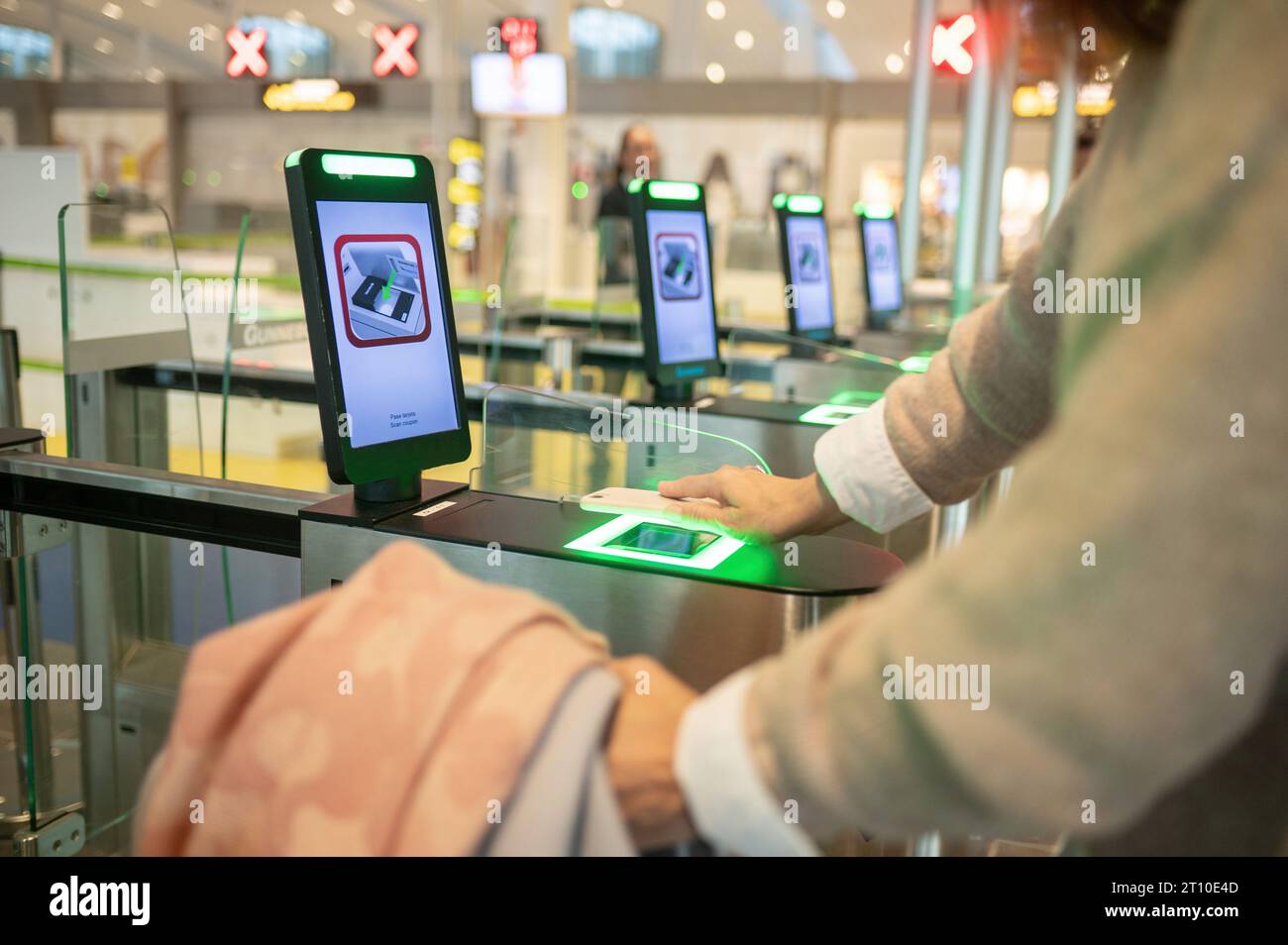 Crop woman using smartphone while scanning info into smart gate pass in ...