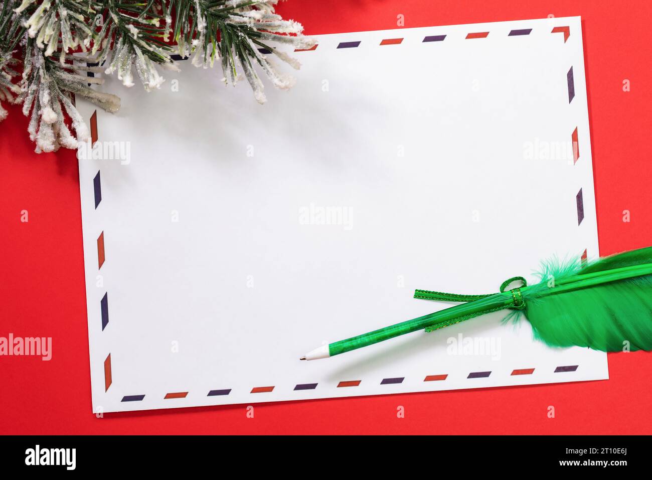 An empty envelope, a fir branch and a quill pen on a red background, a ...
