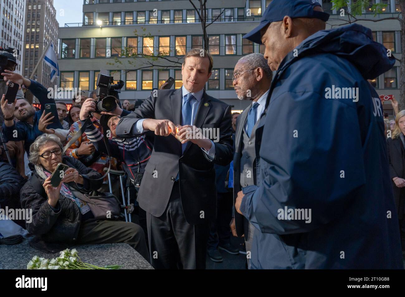 U.S. Representative Dan Goldman lights a candle at a Candlelight Vigil ...