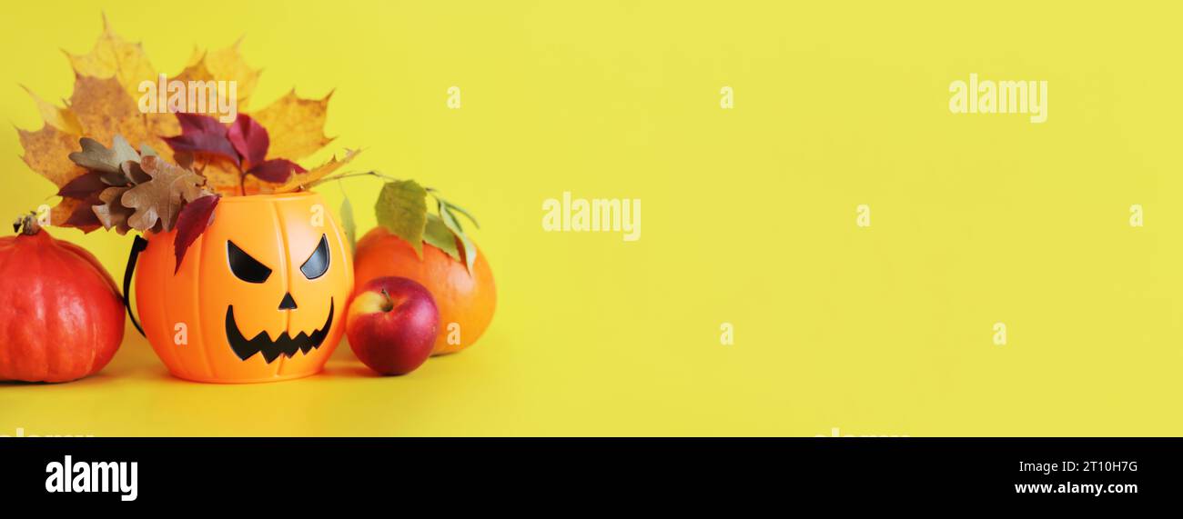 Happy Halloween. Plastic pumpkin bucket with an evil smiling, leaves ...