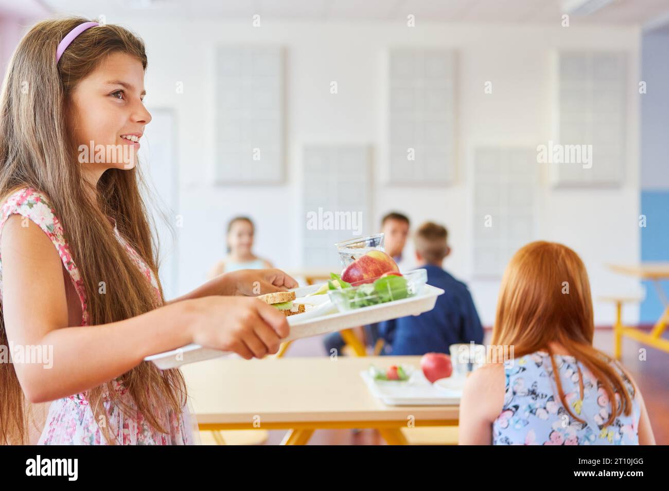 Side View Of Smiling Girl Looking Away While Holding Food Tray In