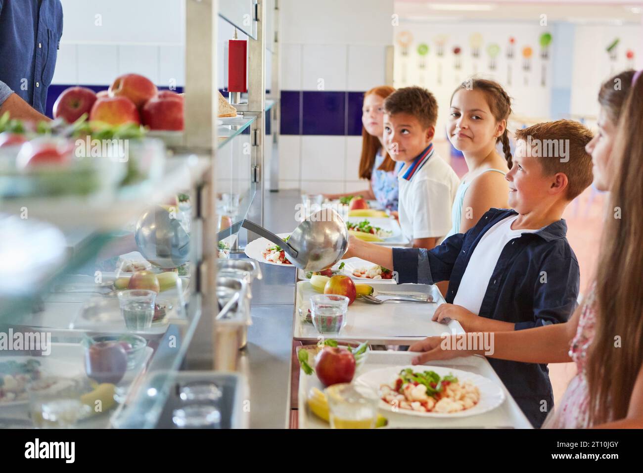 Happy kids in line taking food from cafeteria worker during lunch time at school Stock Photo - Alamy